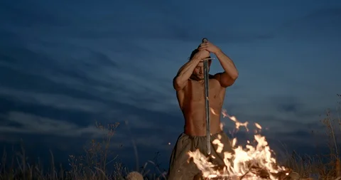 Shirtless warrior putting sword into gro... | Stock Video | Pond5