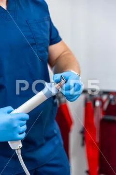 Shock wave therapy device with male doctor hands in rubber gloves ...