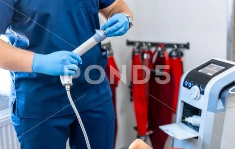 Shock wave therapy device with male doctor hands in rubber gloves ...