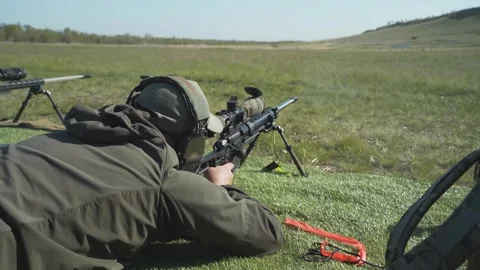 the shooter adjusts the sniper rifle, lo... | Stock Video | Pond5