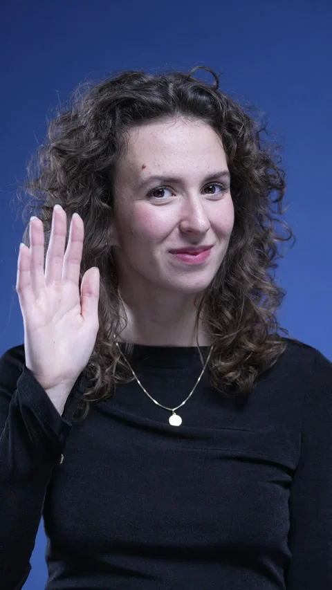 Shy woman waving hello with hand in vert... | Stock Video | Pond5