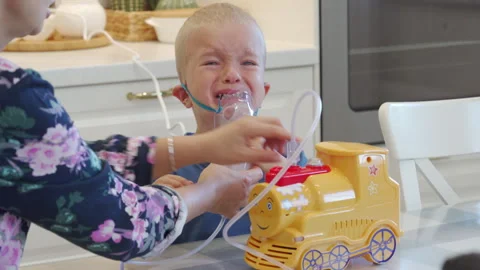 sick child crying while doing inhalation... | Stock Video | Pond5