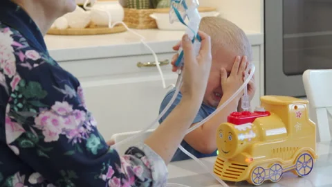 sick child crying while doing inhalation... | Stock Video | Pond5