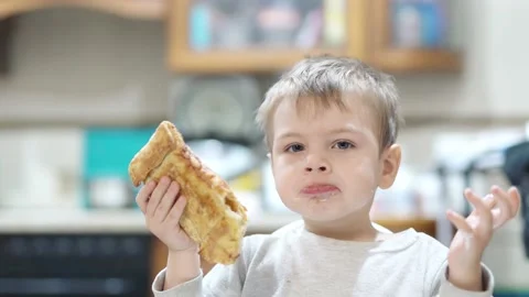 Sick child eating puff in the kitchen | Stock Video | Pond5