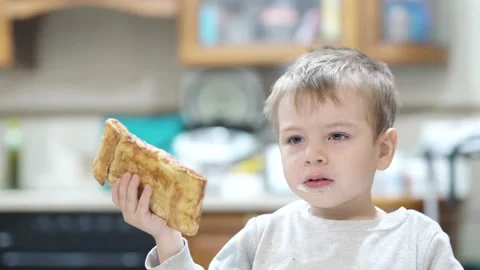 Sick child eating puff in the kitchen | Stock Video | Pond5