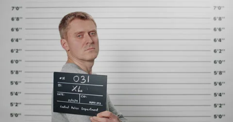 Side profile mugshot of man holding sign... | Stock Video | Pond5