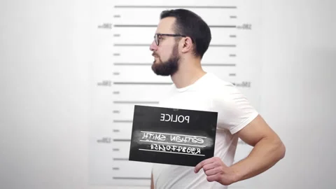 Side profile mugshot of man holding sign... | Stock Video | Pond5