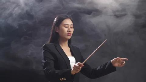 Side View Of Asian Conductor Woman Holdi... | Stock Video | Pond5