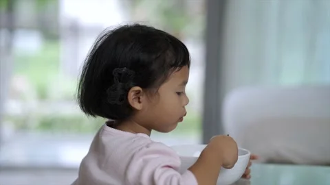 Side view of Asian little girl eating ch... | Stock Video | Pond5