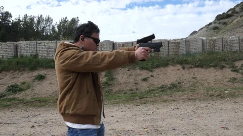 side view of man alternating shooting tw... | Stock Video | Pond5