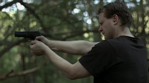 Side view of a man firing a pistol in wo... | Stock Video | Pond5