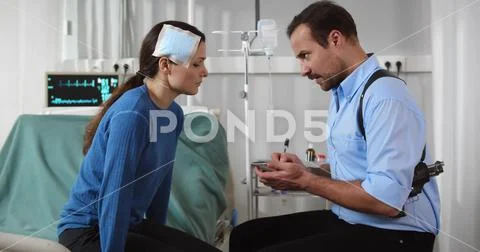 Side view of policeman interviewing victim woman sitting on bed in ...
