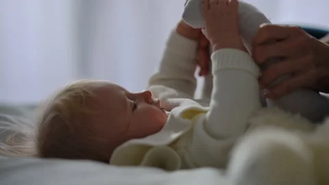 Side view relaxed baby girl playing with... | Stock Video | Pond5