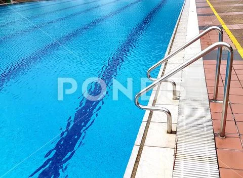 Side view of swimming pool with sparkling clear blue water and lines ...