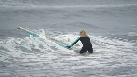 Side view young female surfer in wetsuit... | Stock Video | Pond5