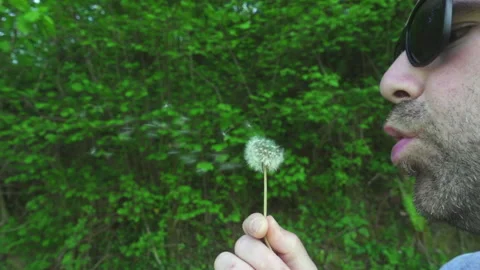 Side view of young man walking and blowi... | Stock Video | Pond5