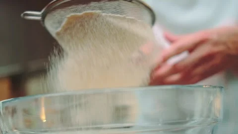 Sifting flour through a sieve into a gla... | Stock Video | Pond5