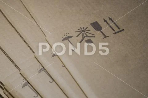 Signs on a cardboard box. Black-printed badges and symbols about the ...