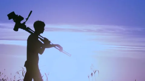 Silhouette of a cameraman with a tripod ... | Stock Video | Pond5