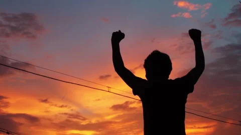 Silhouette of a kid raising his arms in ... | Stock Video | Pond5
