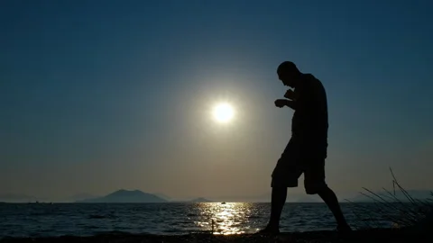 Silhouette man training boxing by ocean. | Stock Video | Pond5