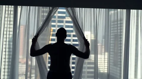Silhouette of man unveil curtains and ad... | Stock Video | Pond5