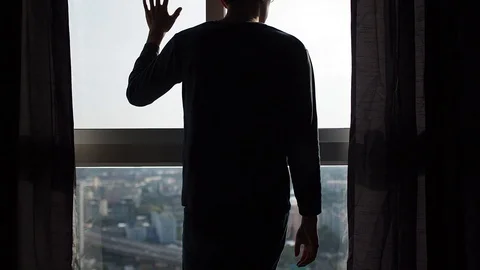 Silhouette of man walking to window and ... | Stock Video | Pond5