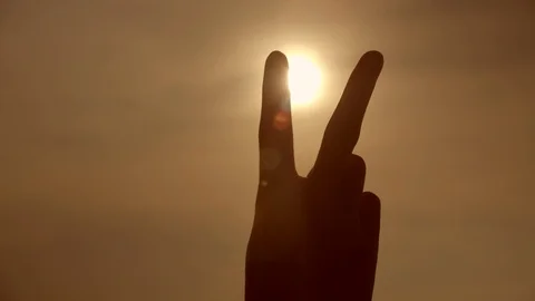 Silhouette of Peace sign with hands at s... | Stock Video | Pond5