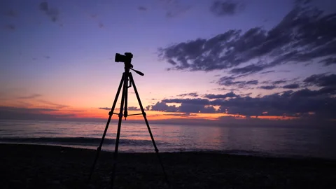 Silhouette of tripod with dslr camera at... | Stock Video | Pond5