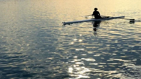 Silhouette of woman rowing in a canoe at... | Stock Video | Pond5