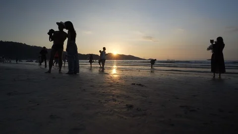 Silhouettes of beach goers during sunset... | Stock Video | Pond5