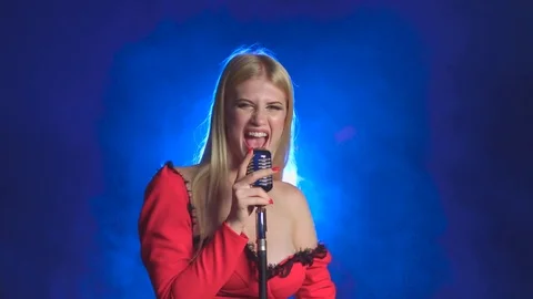 Singer in a red dress is singing into a ... | Stock Video | Pond5