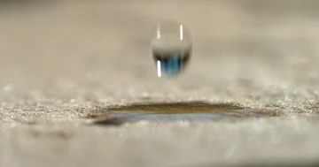 Single drop of rain on dry ground super ... | Stock Video | Pond5