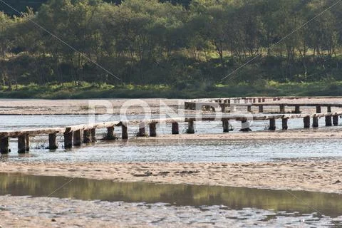 Single lane log bridge over a shallow river Stock Photo #45120900