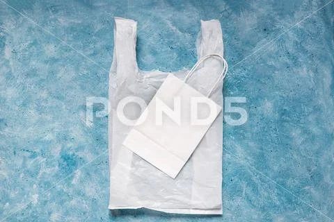 Photograph: Single use plastic bag next to paper one, plastic pollution ...