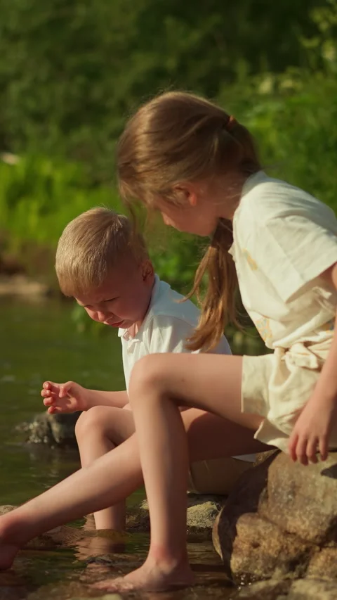 Sister and brother play with river water... | Stock Video | Pond5