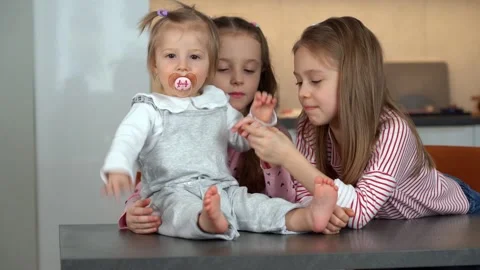 Sisters laugh and funny play with baby g... | Stock Video | Pond5