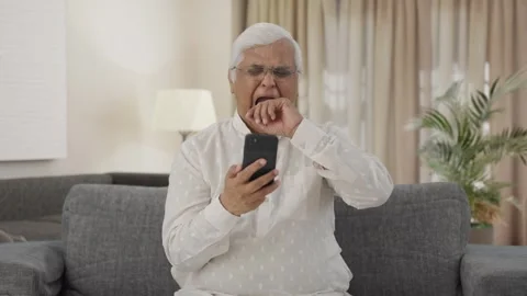 Sleepy Indian old man scrolling phone | Stock Video | Pond5