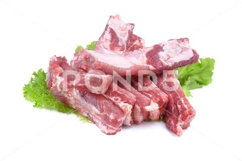 Sliced pork ribs on a lettuce leaf are isolated on a white background ...