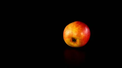 Sliding apple on a black background. | Stock Video | Pond5
