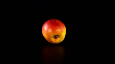 Sliding apple on a black background. | Stock Video | Pond5