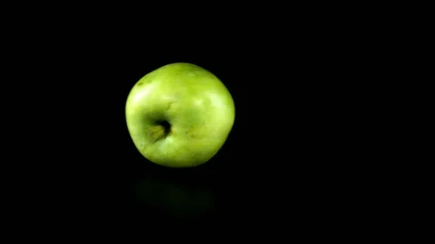 Sliding apple on a black background. | Stock Video | Pond5