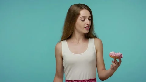 Slim beautiful girl smelling donut and b... | Stock Video | Pond5