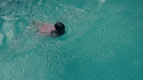 Slow Motion Girl swimming across a pool | Stock Video | Pond5