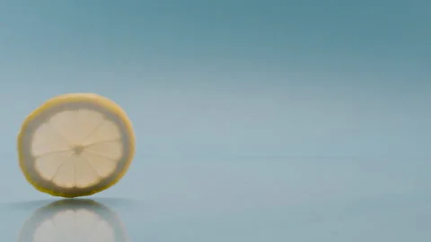 Slow Motion a Lemon Slice fall on blue b... | Stock Video | Pond5