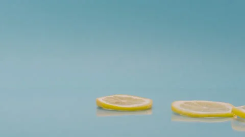 Slow Motion a Lemon Slice fall on blue b... | Stock Video | Pond5