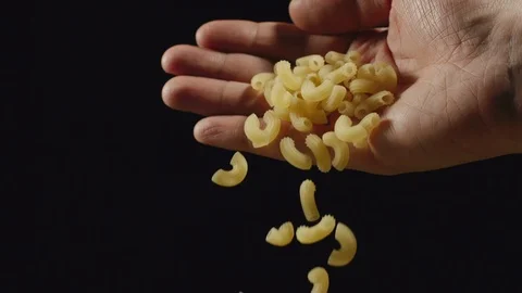 SLOW MOTION: Macaroni falling from a han... | Stock Video | Pond5