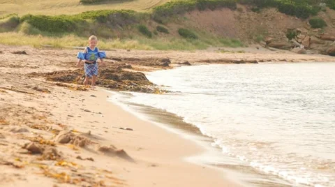 Slow motion shot boy running through oce... | Stock Video | Pond5