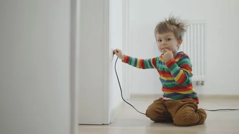 Small boy playing with electrical plug i... | Stock Video | Pond5