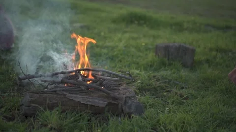 Small fire burning in the field as peopl... | Stock Video | Pond5